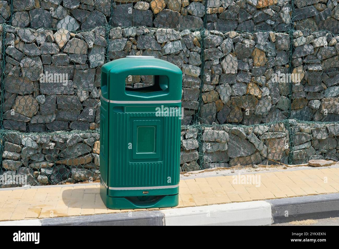 Plastic trash can on gabion wall background made of wire mesh filled ...