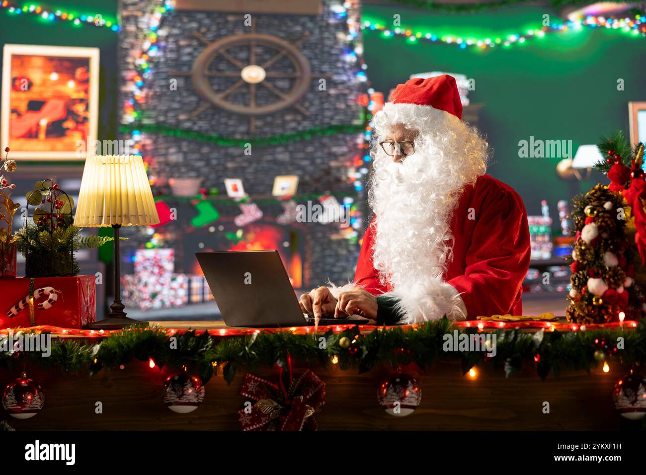 Father Christmas is browsing websites on his laptop and checking ...