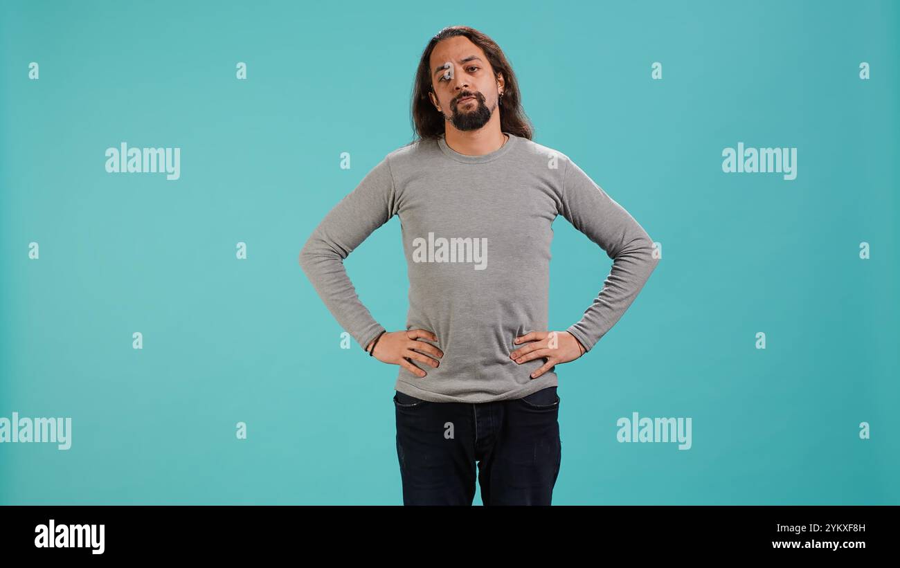 Portrait of man standing confidently with hands on hips, posing against ...