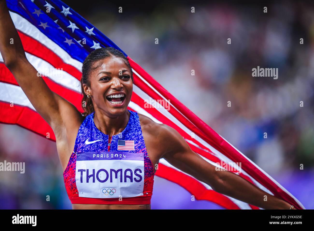 Gabrielle Thomas celebrating with her country's flag in the 200 meters ...