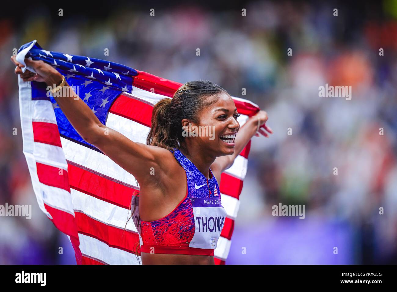 Gabrielle Thomas celebrating with her country's flag in the 200 meters ...