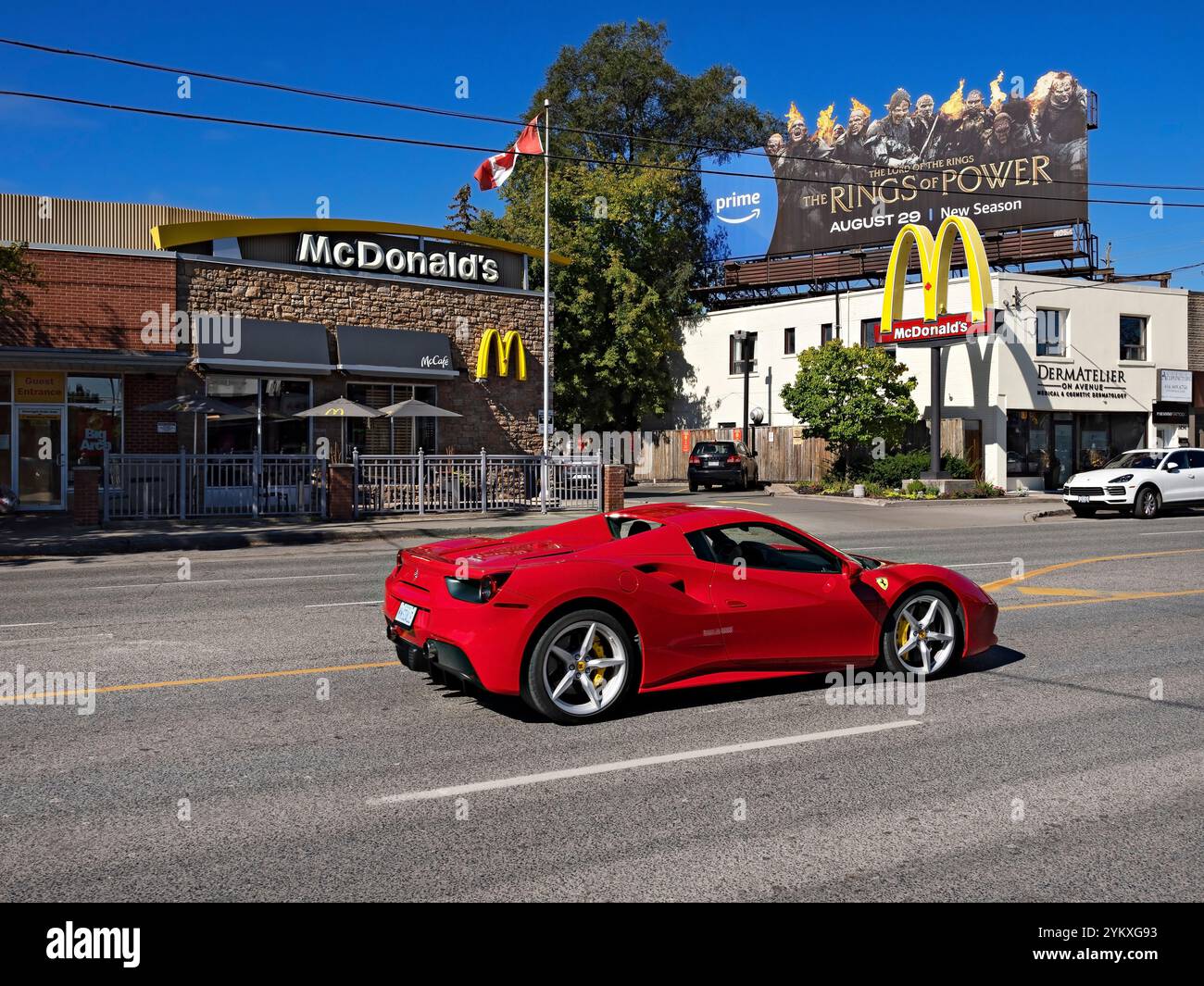 Toronto Canada / A Red Ferrari passing McDonalds Restaurant on Avenue ...