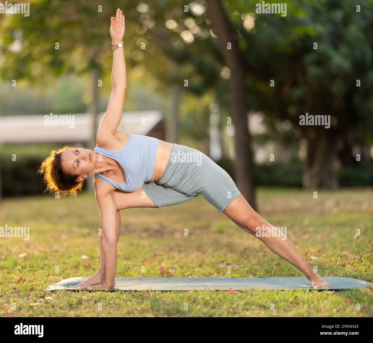 Slim woman practicing yoga - virabhadrasana pose in summer park Stock ...