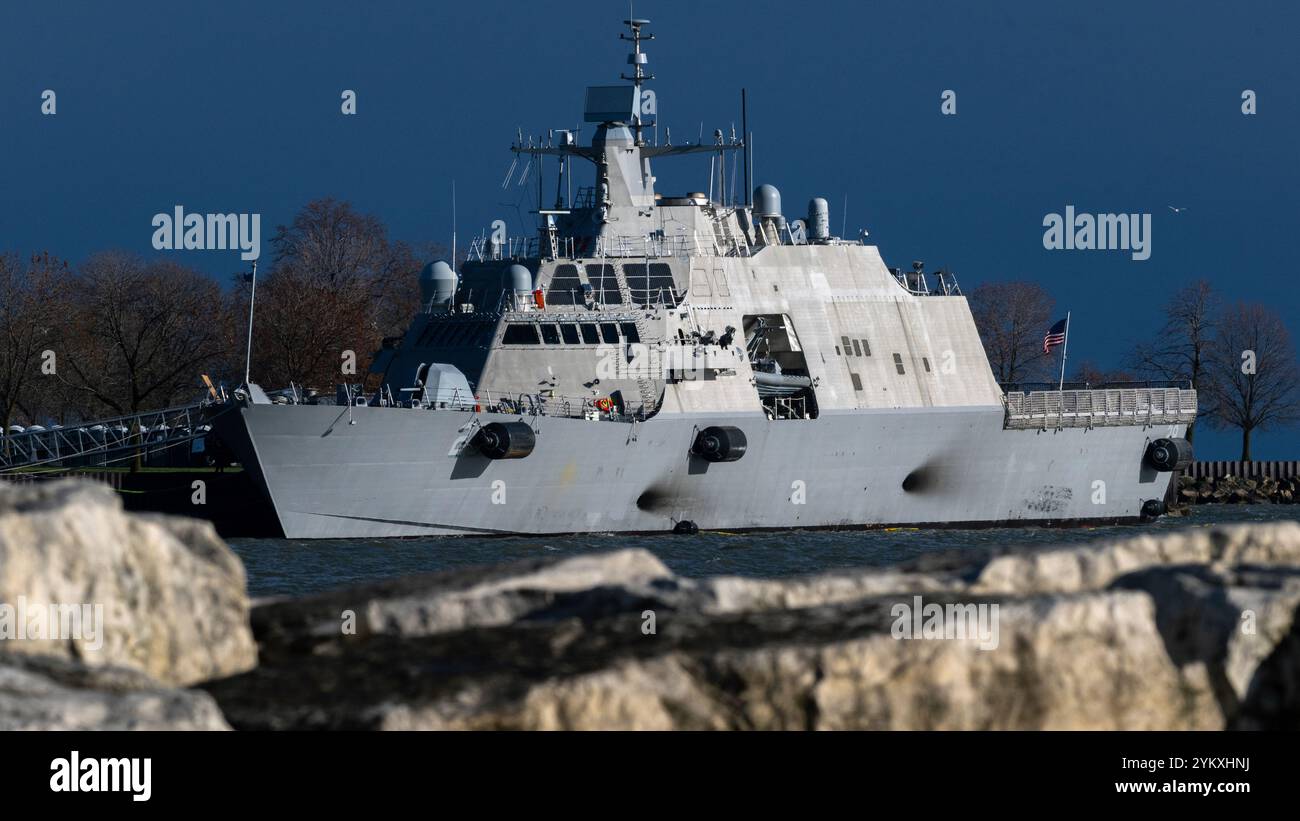 Sunshine breaks through a rainy morning to shine upon the USS Beloit ...