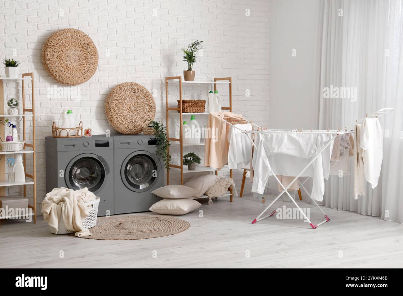 Interior of laundry room with grey washing machines and clean clothes ...