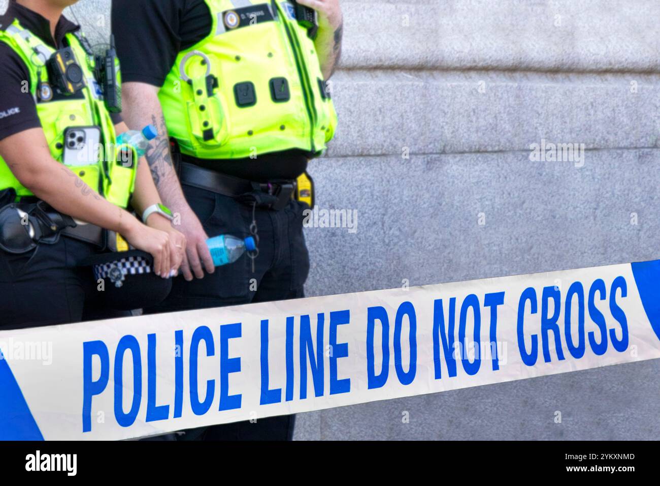 Blue and white police line do not cross crime scene tape in focus with ...