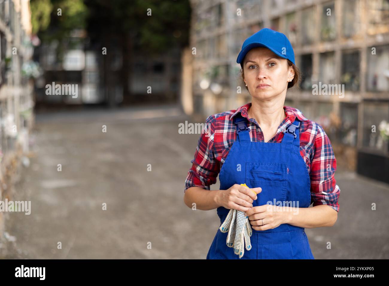 Female cemetery worker standing near columbarium wall Stock Photo - Alamy