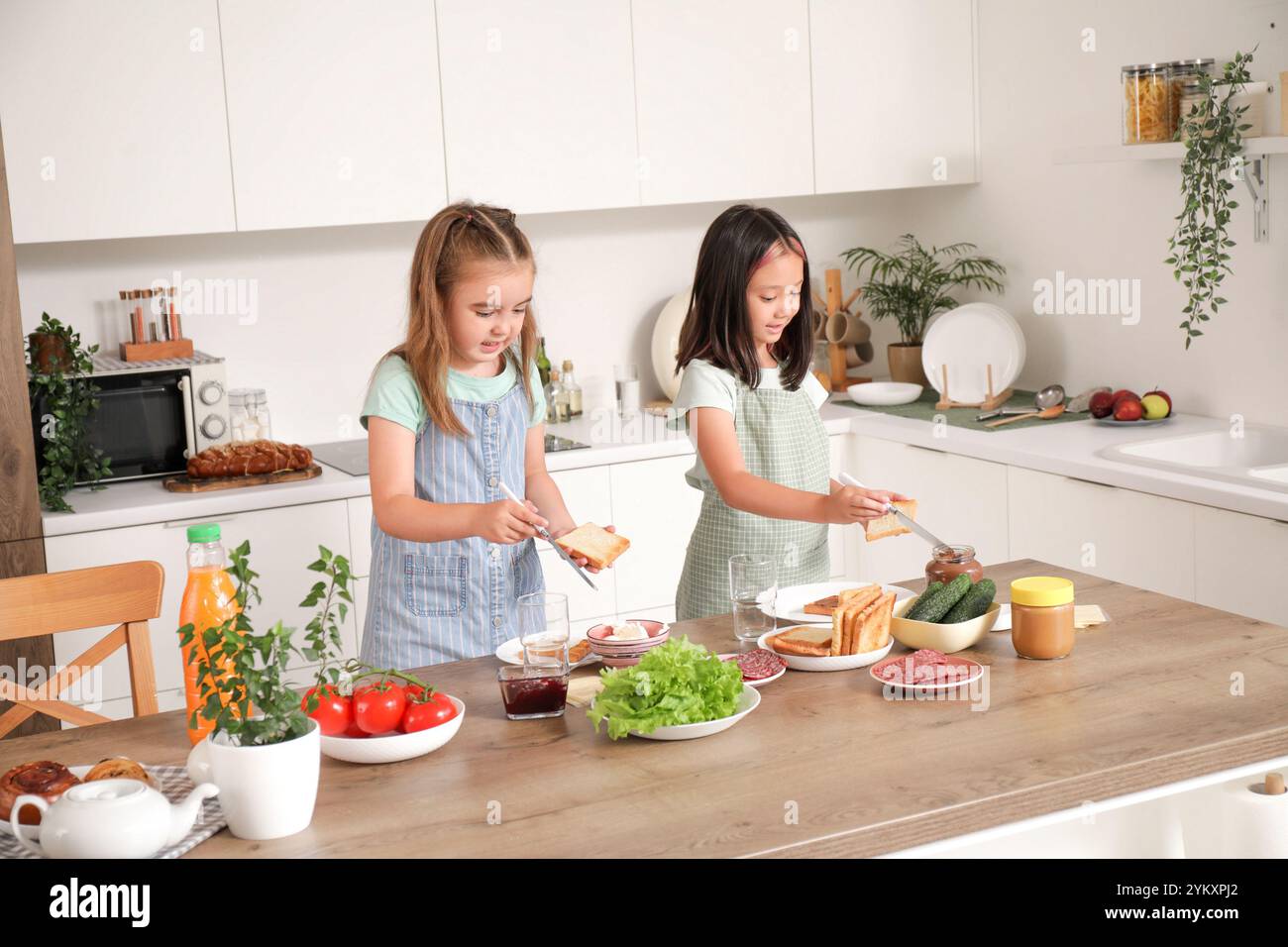 Cute little girls making toasts in kitchen Stock Photo - Alamy
