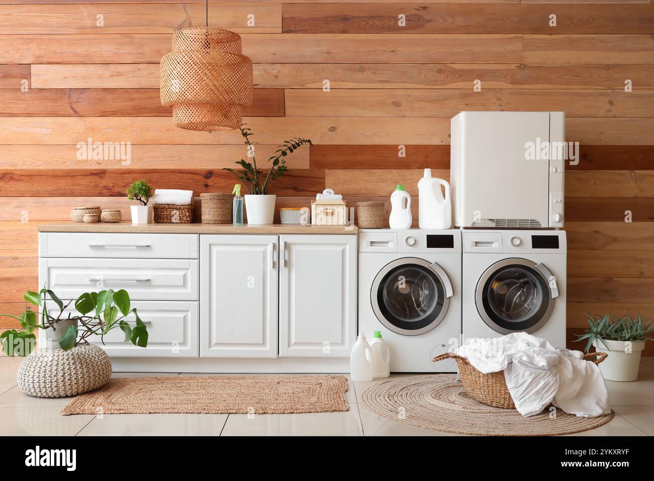 Interior of home laundry room with modern two washing machines, counter ...
