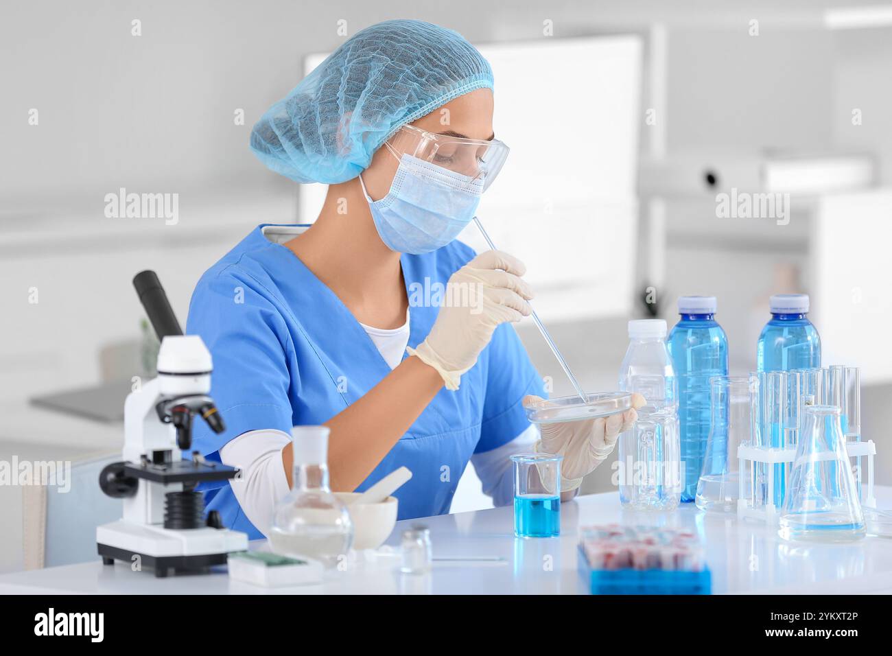 Female young scientist with professional glassware examining water ...