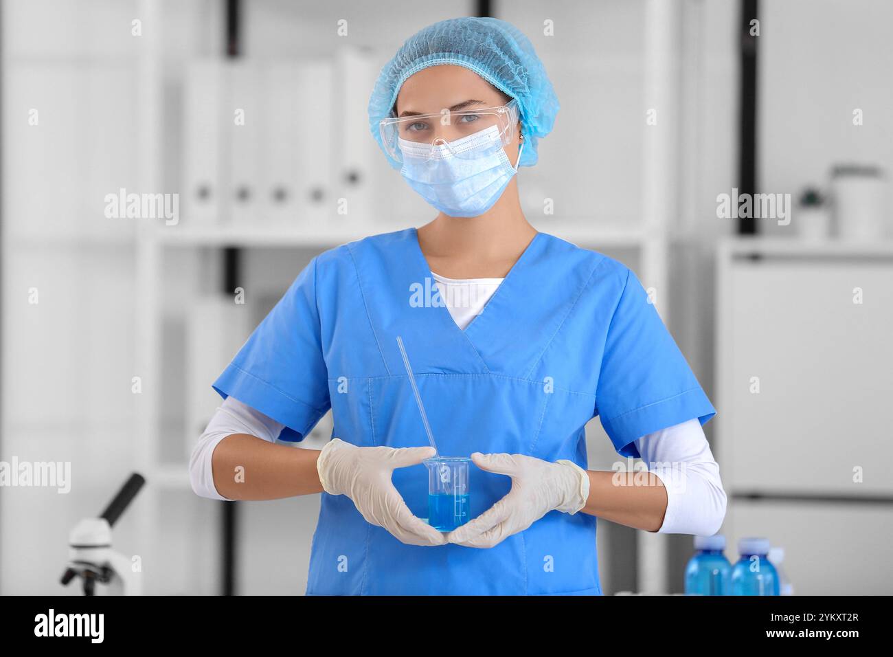 Female young scientist with flask of water sample in research ...