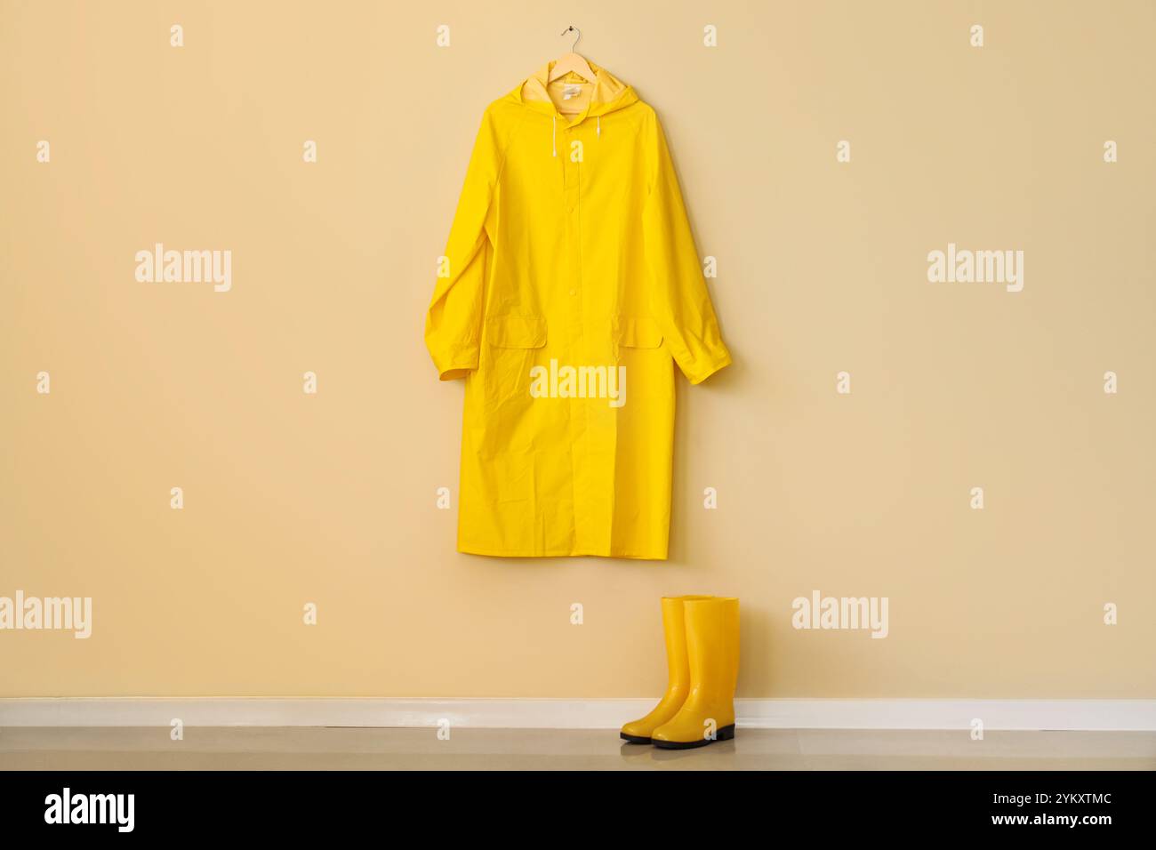 Yellow gumboots and raincoat on beige wall in hallway Stock Photo - Alamy