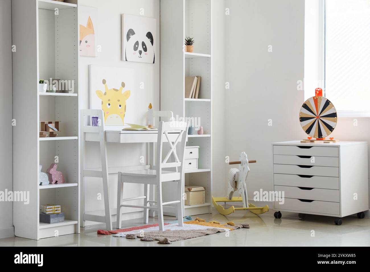 Interior of children's room with table, shelving units and animal ...