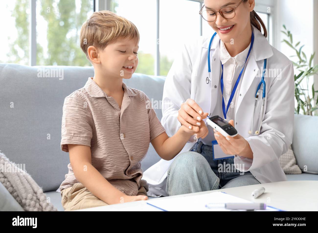 Little diabetic boy with doctor using glucometer at home Stock Photo ...