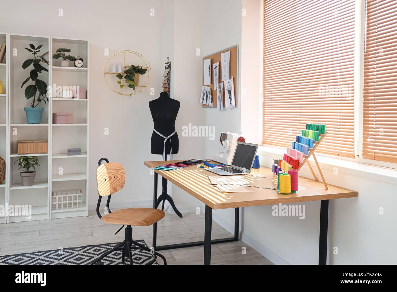 Interior of light atelier with tailor's workplace, shelf unit and ...