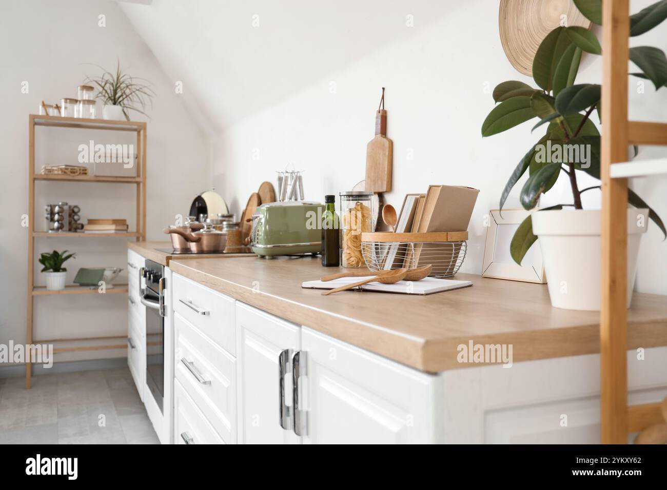 Books with utensils on counter in light kitchen interior Stock Photo ...
