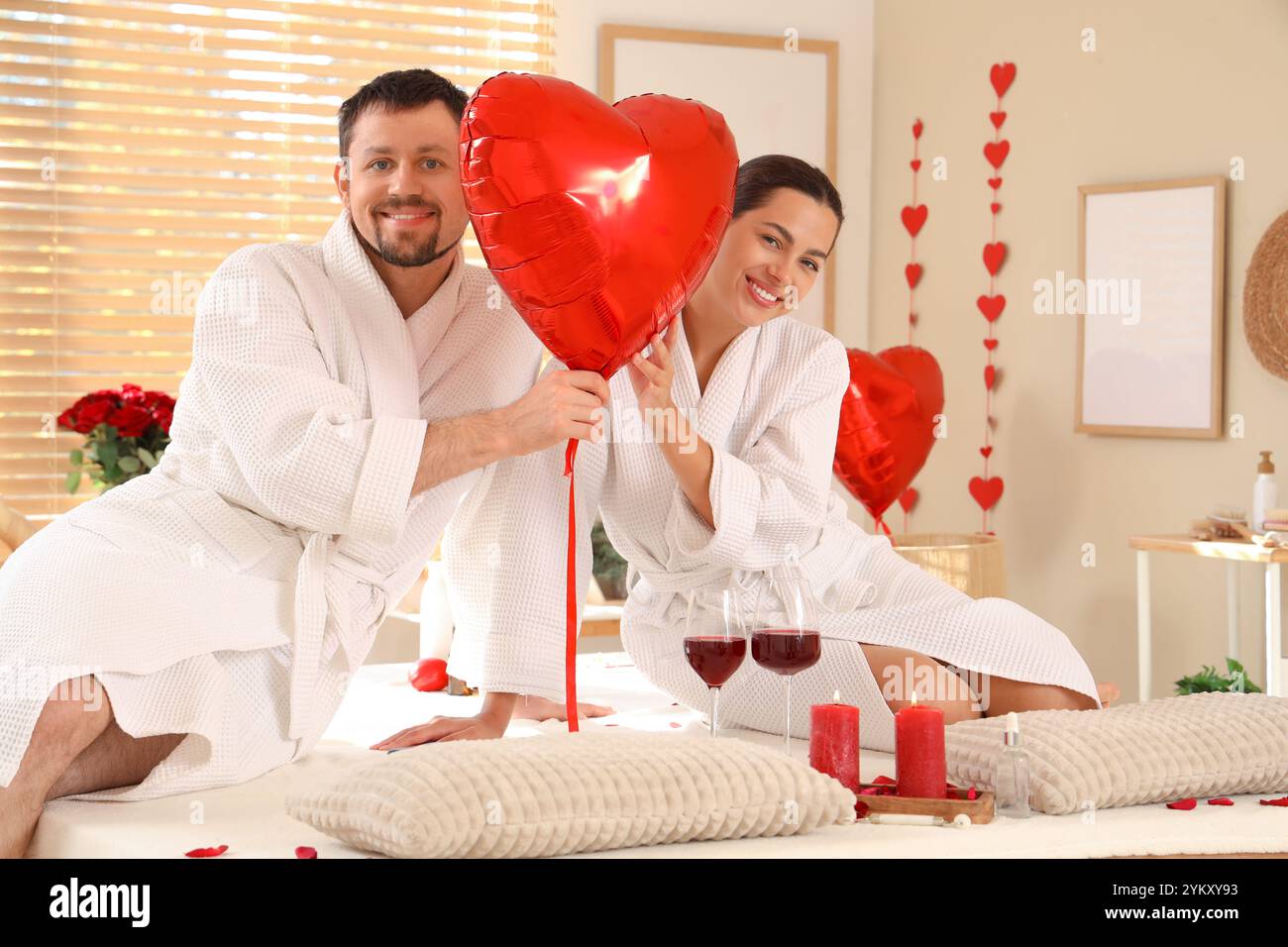 Young couple with heart-shaped balloon in spa salon on Valentine's Day ...