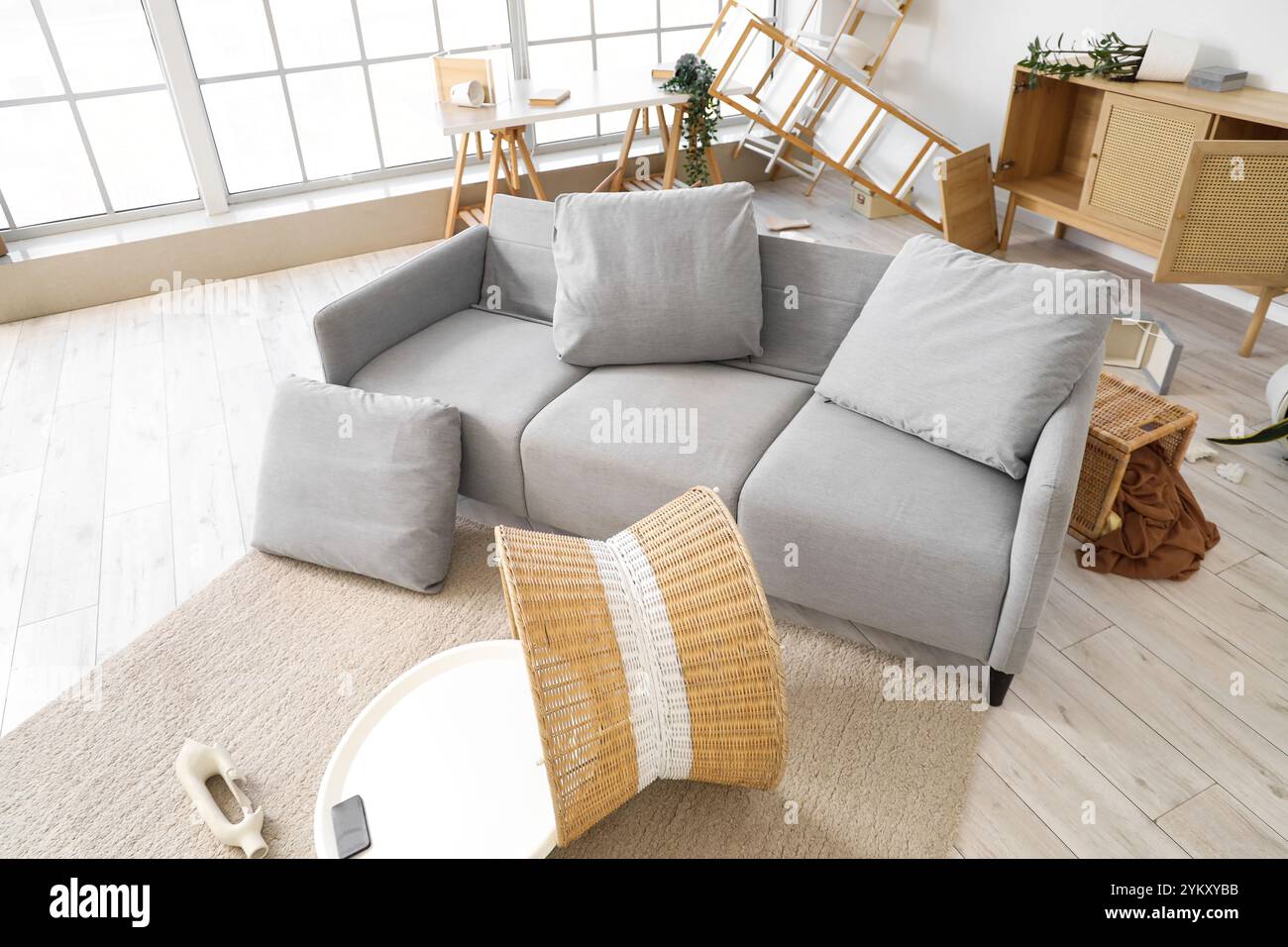 Interior of messy living room with sofa and overturned table after ...