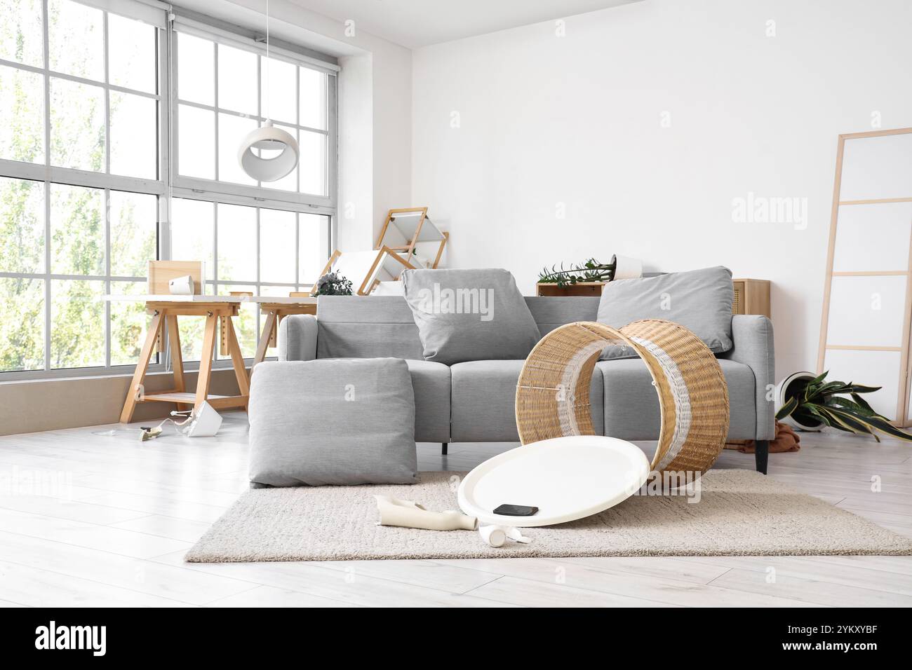 Interior of messy living room with sofa and overturned table after ...