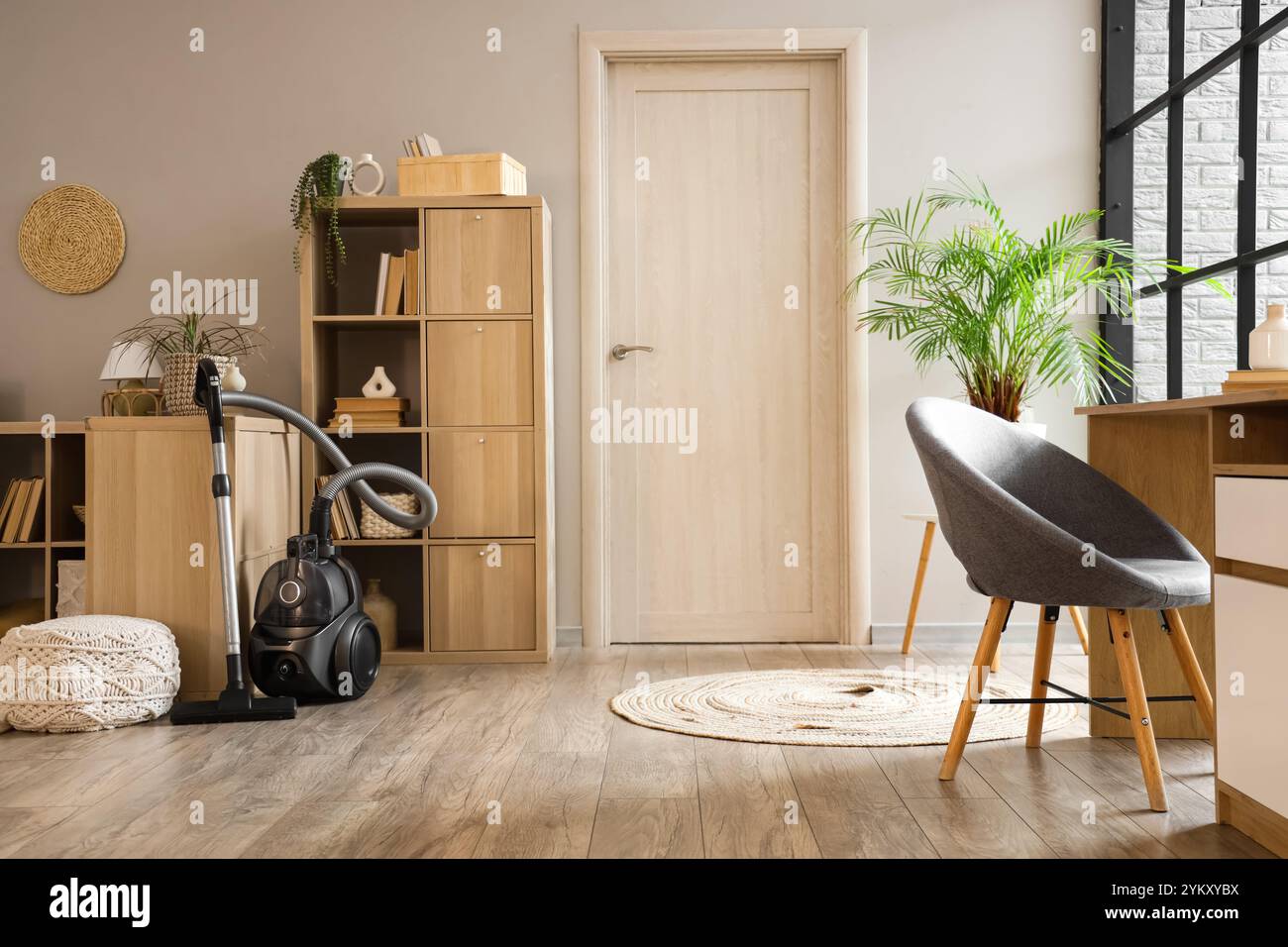 Interior of living room with vacuum cleaner, bookshelf and door Stock ...