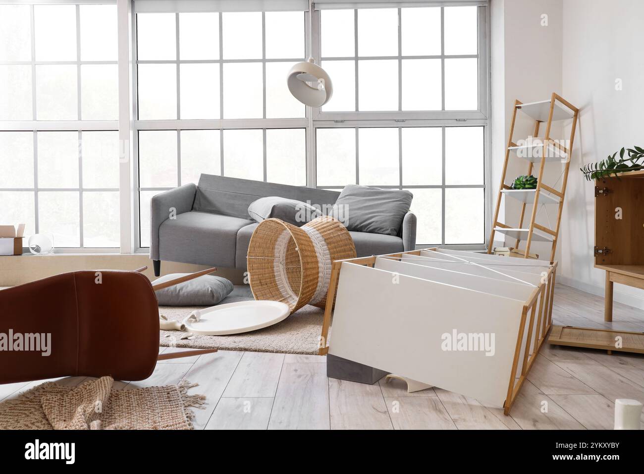 Interior of messy living room with sofa, overturned table and shelf ...