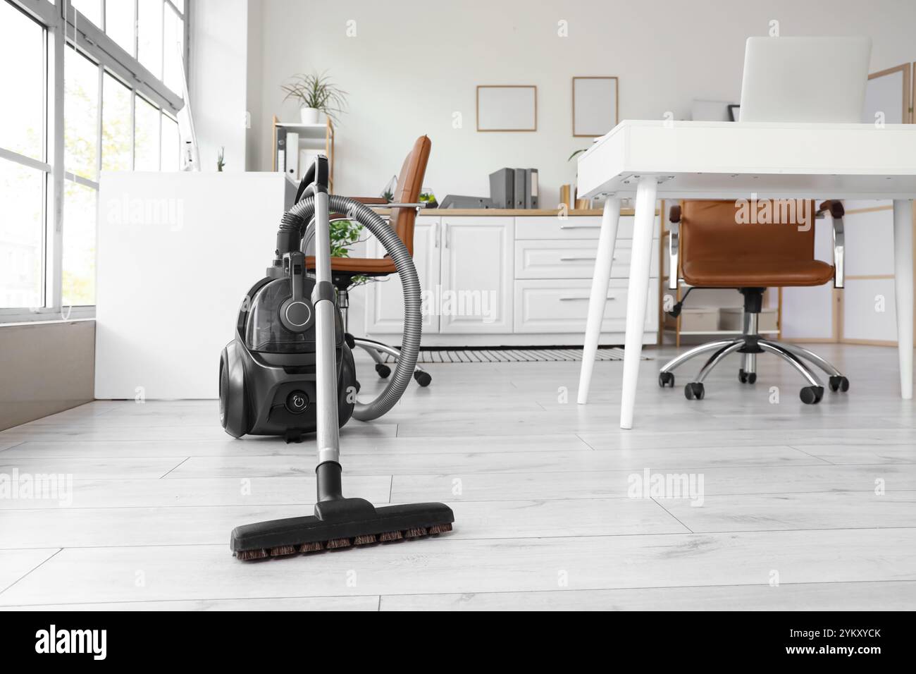 Interior of office with vacuum cleaner and desks Stock Photo - Alamy