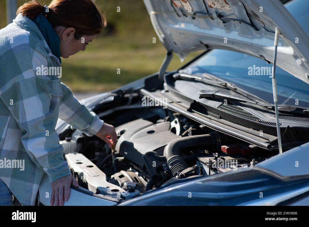 Caucasian female driver checking oil level in car engine Stock Photo ...