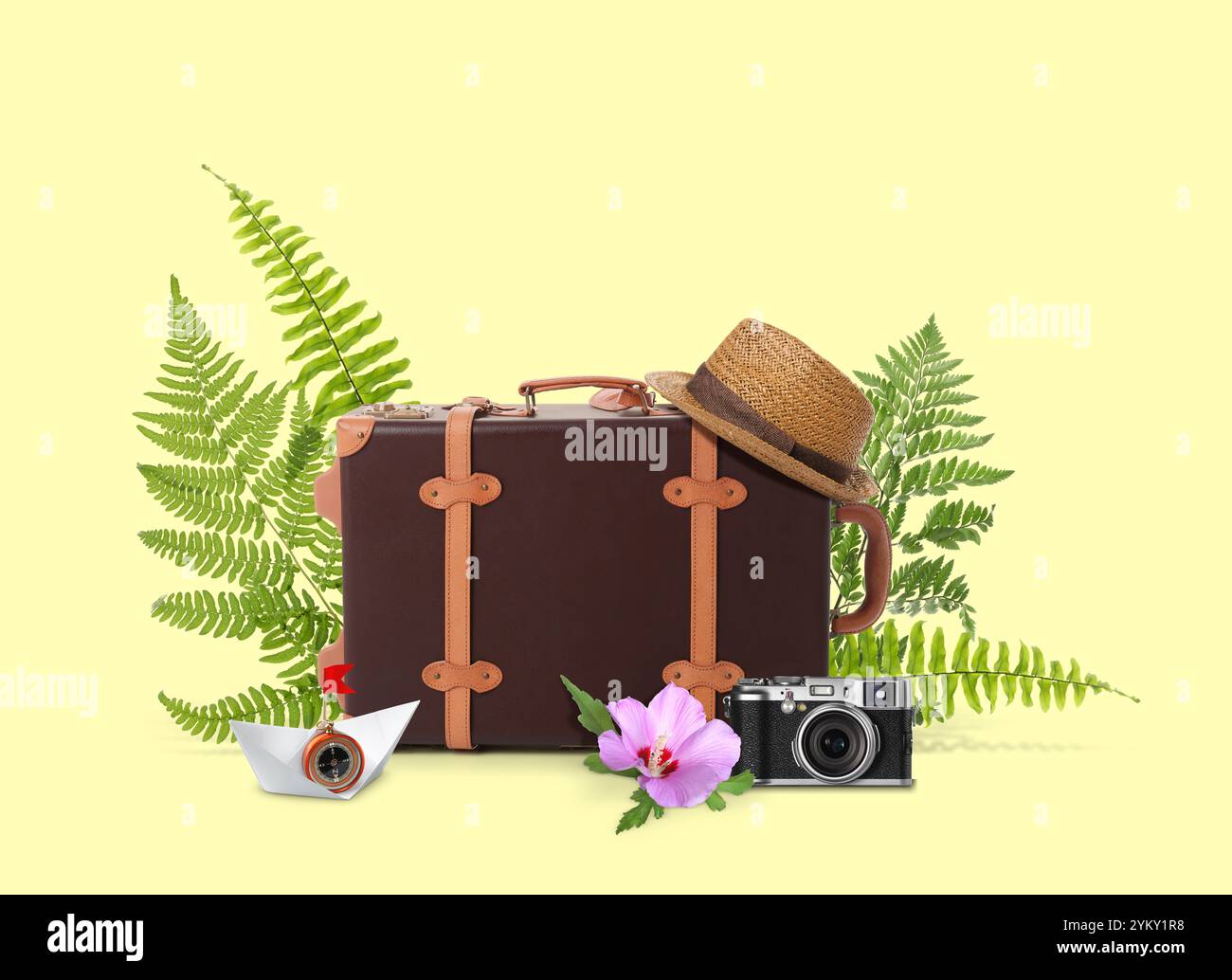 Leather travel suitcase, paper boat with compass, hat, camera, tropical ...