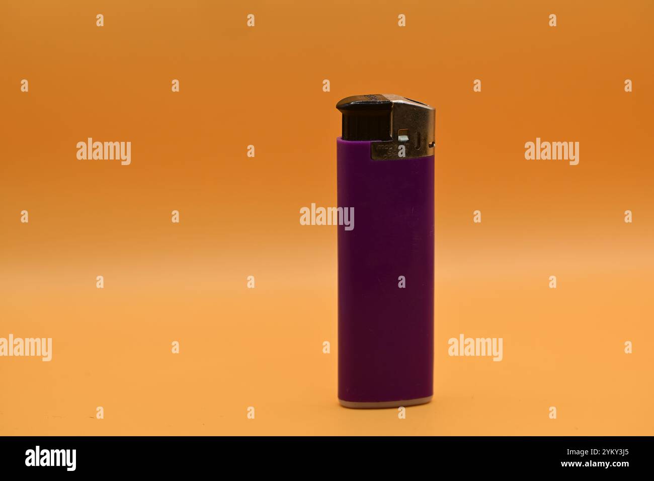 Purple lighter against an orange background Stock Photo - Alamy