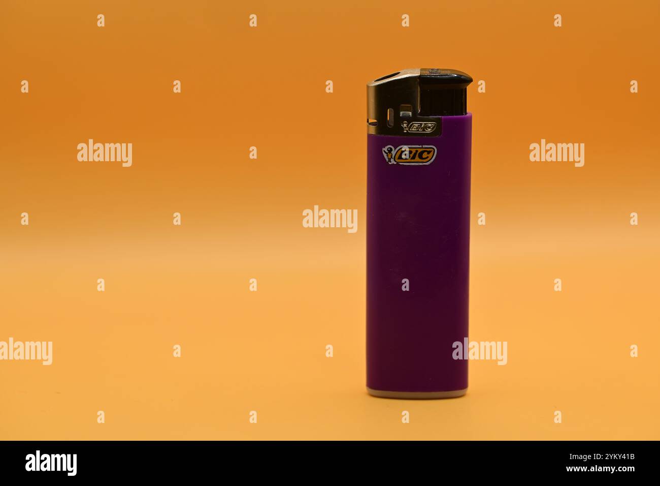 Purple lighter against an orange background Stock Photo - Alamy