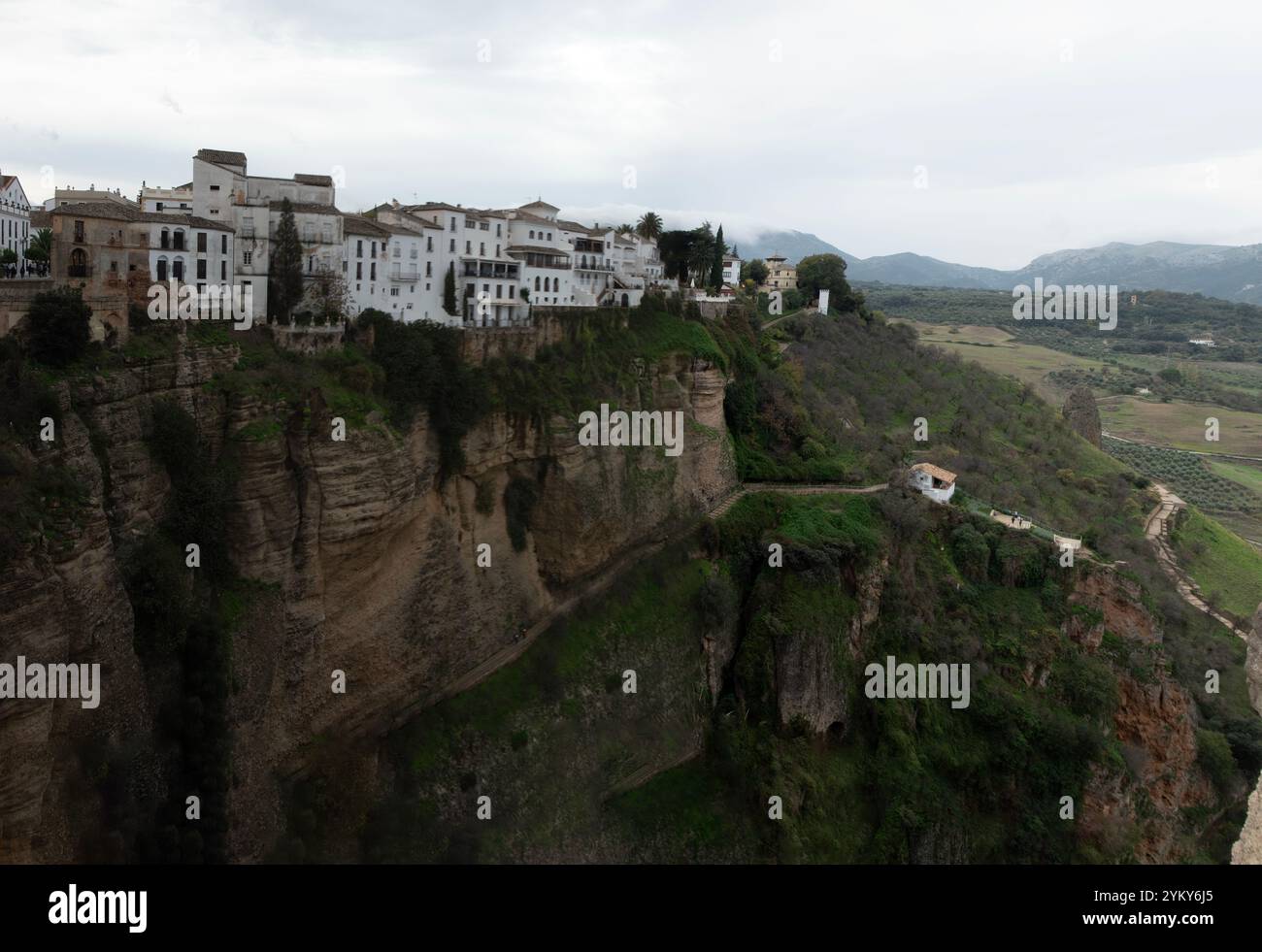 Cliff side view of Ronda in Spain, with white buildings built onto of ...