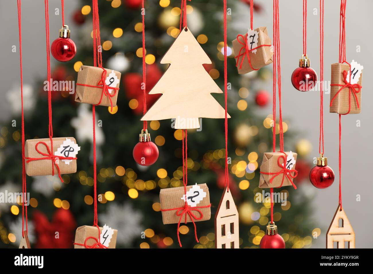 Handmade advent calendar with decor hanging near Christmas tree indoors ...