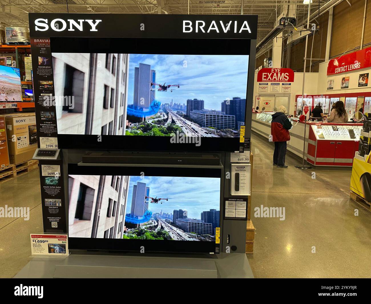 Big-screen televisions stand on display as a shopper heads to the ...