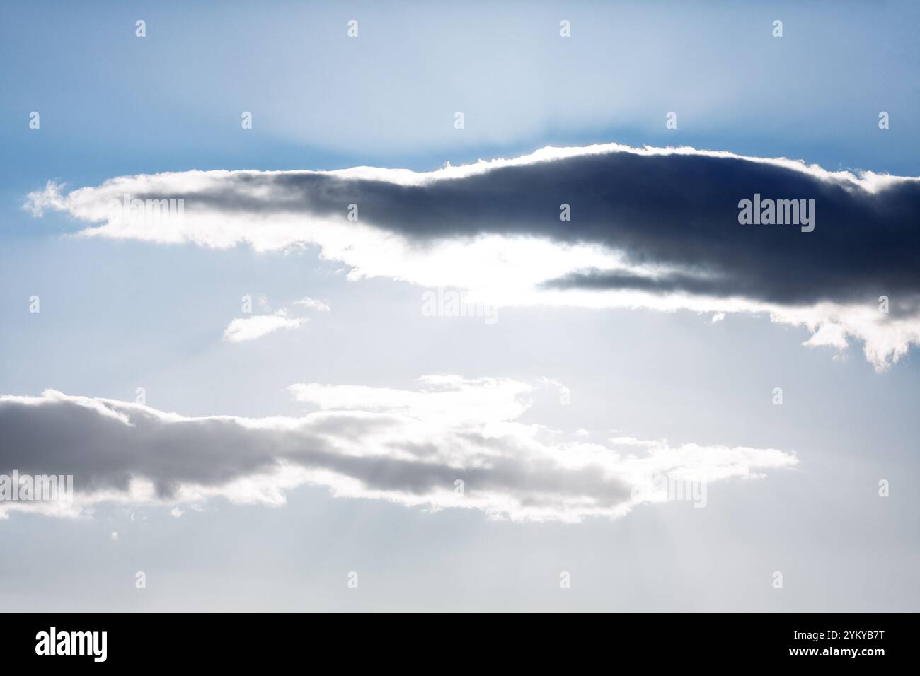 Bright blue sky filled with fluffy clouds and radiant sunbeams shining ...