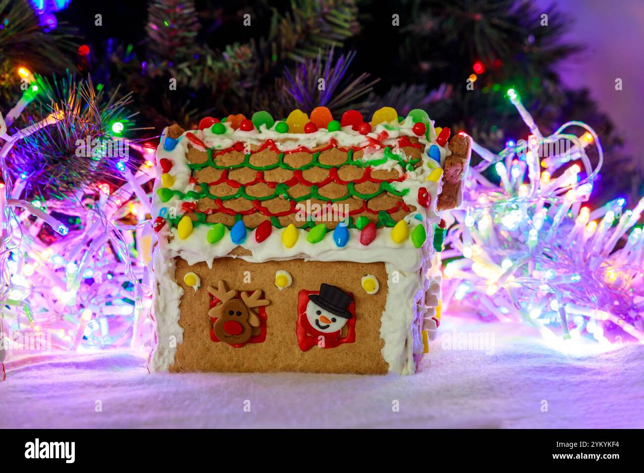 Colorful gingerbread house decorated with frosting and candies during ...