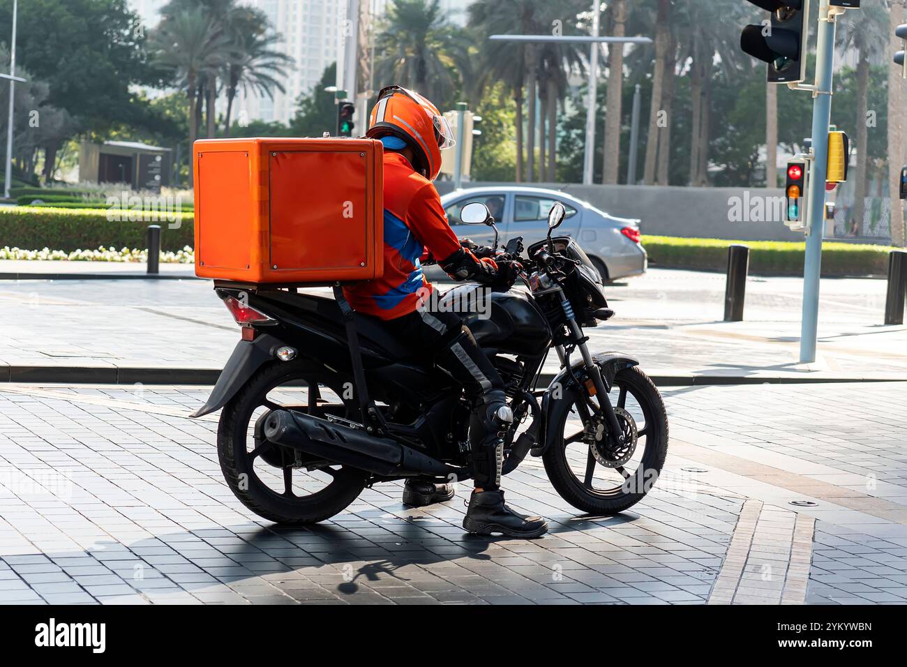 Motorbike delivery man wearing orange uniform and ready to send food ...