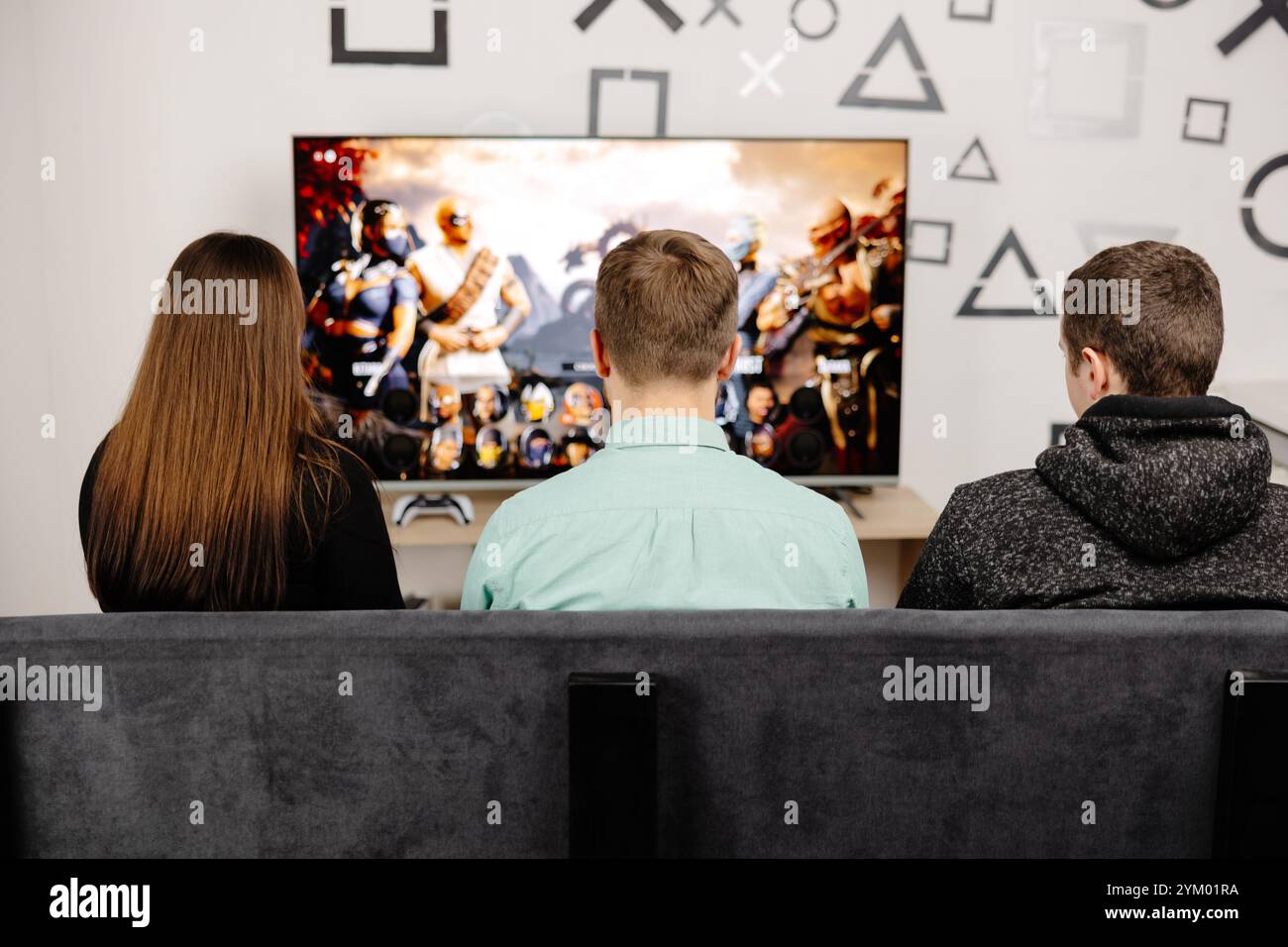 Three friends play video games using a joystick. Young people are ...