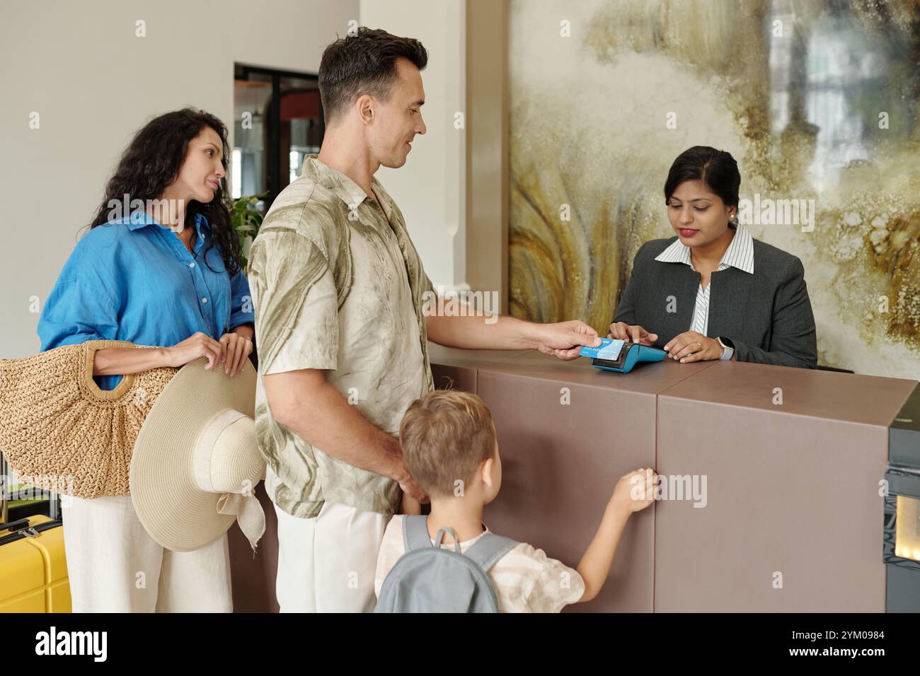 Family Checking in at Concierge Desk of Hotel Stock Photo - Alamy
