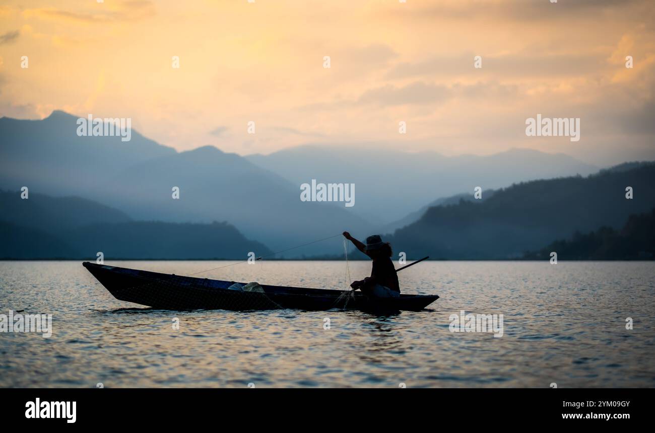 Lonely fisherman on the boat fishing in Phewa lake, Nepal Stock Photo ...