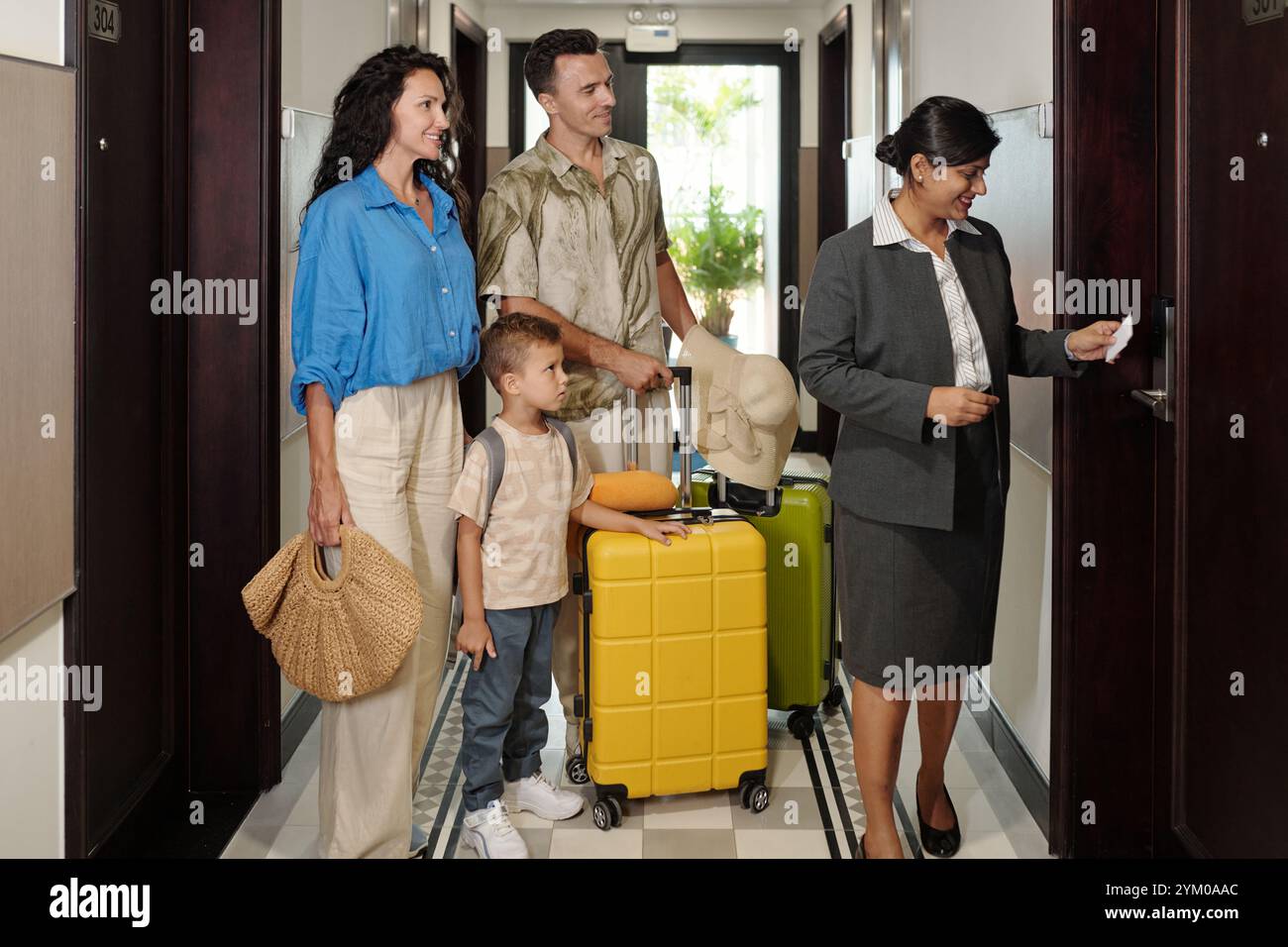Family Touring Hotel Corridor With Luggage Stock Photo - Alamy