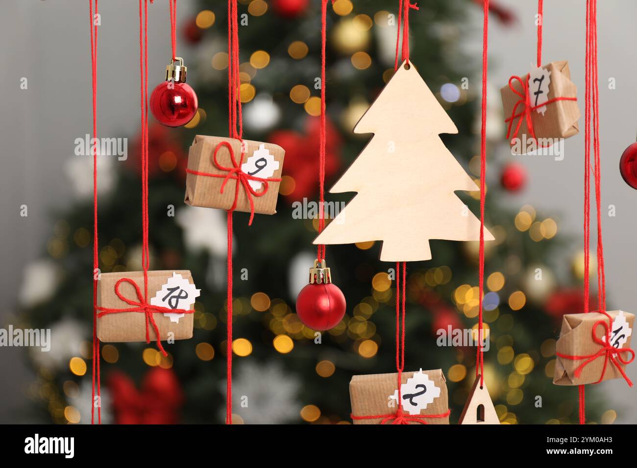 Handmade advent calendar with decor hanging near Christmas tree indoors ...