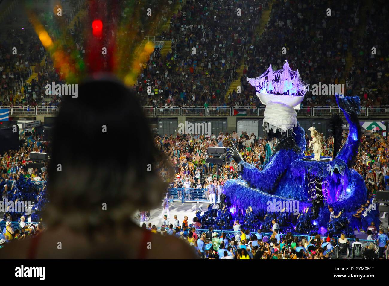 A spectator watches the Portela samba school pass by from the popular ...