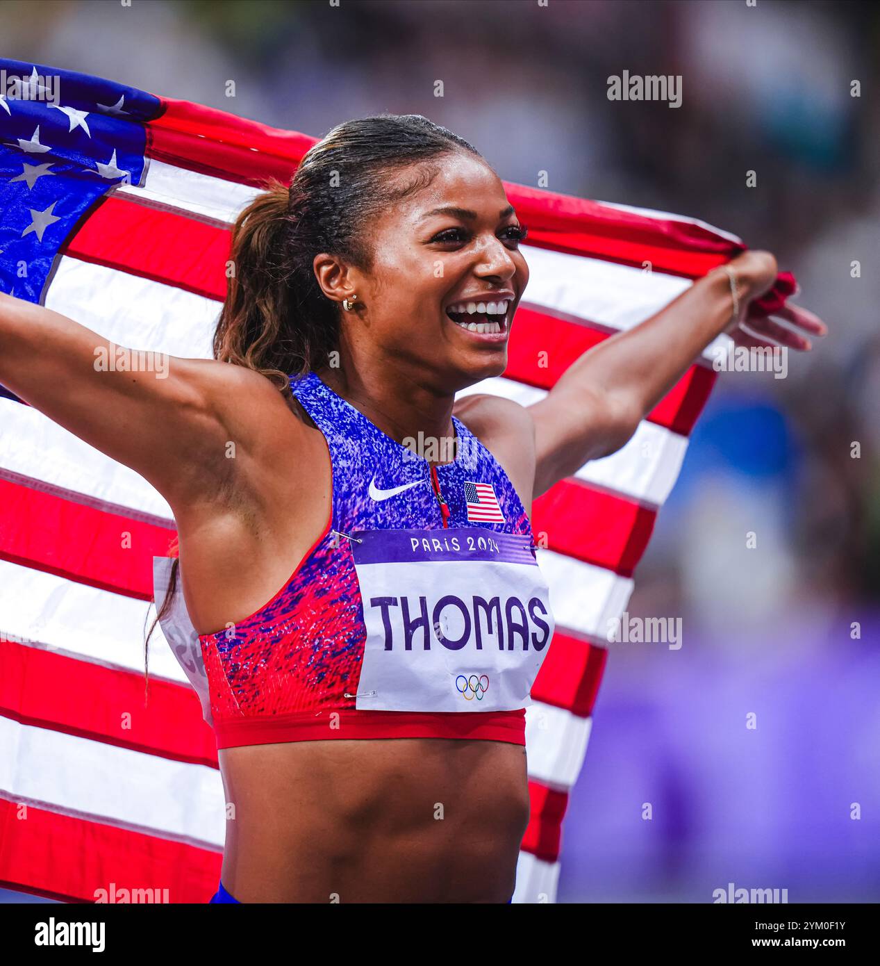Gabrielle Thomas celebrating with her country's flag in the 200 meters ...