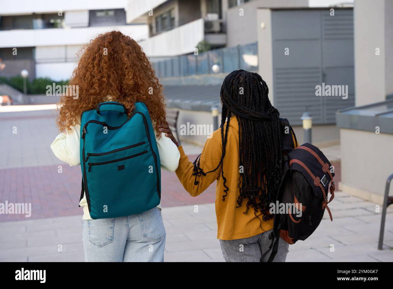 Two female students walking together on campus after class Stock Photo ...