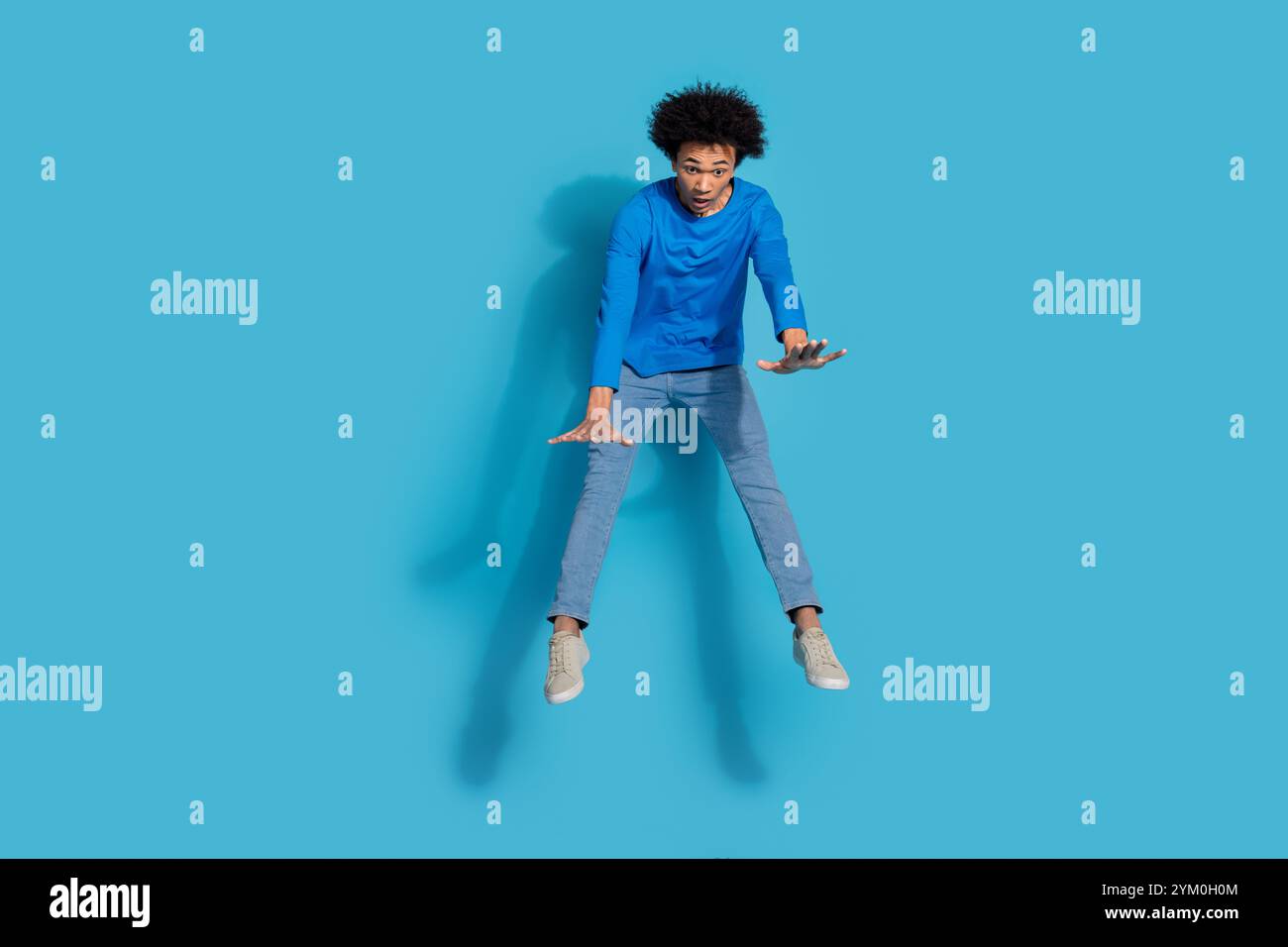 Full body photo of attractive young man jumping pushing invisible ...