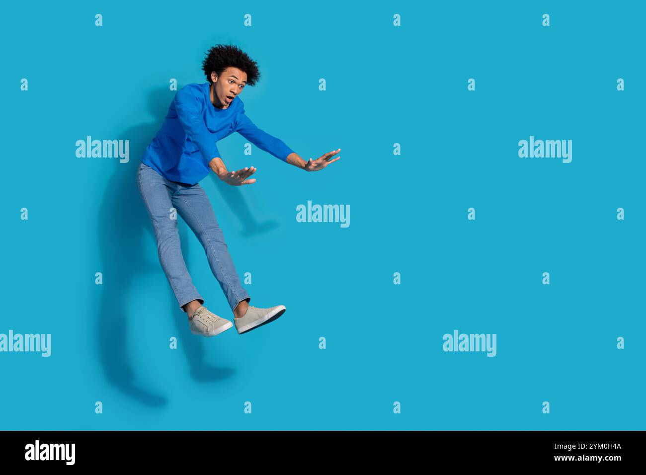 Full body photo of attractive young man jumping pushing invisible ...