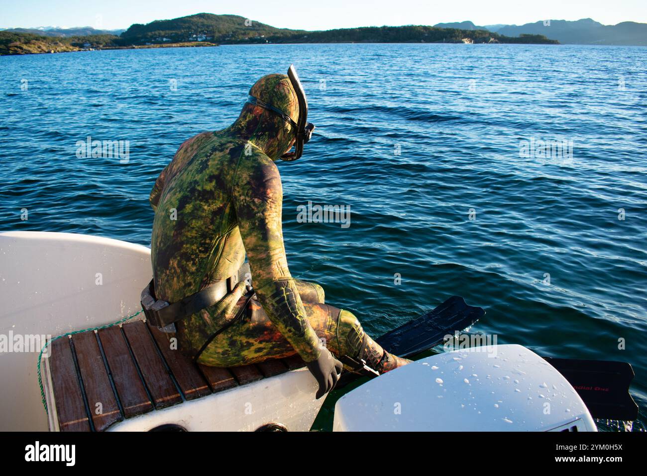 Diver in Scuba wetsuit jumping off a boat to Snorkel – Norway Vacations ...