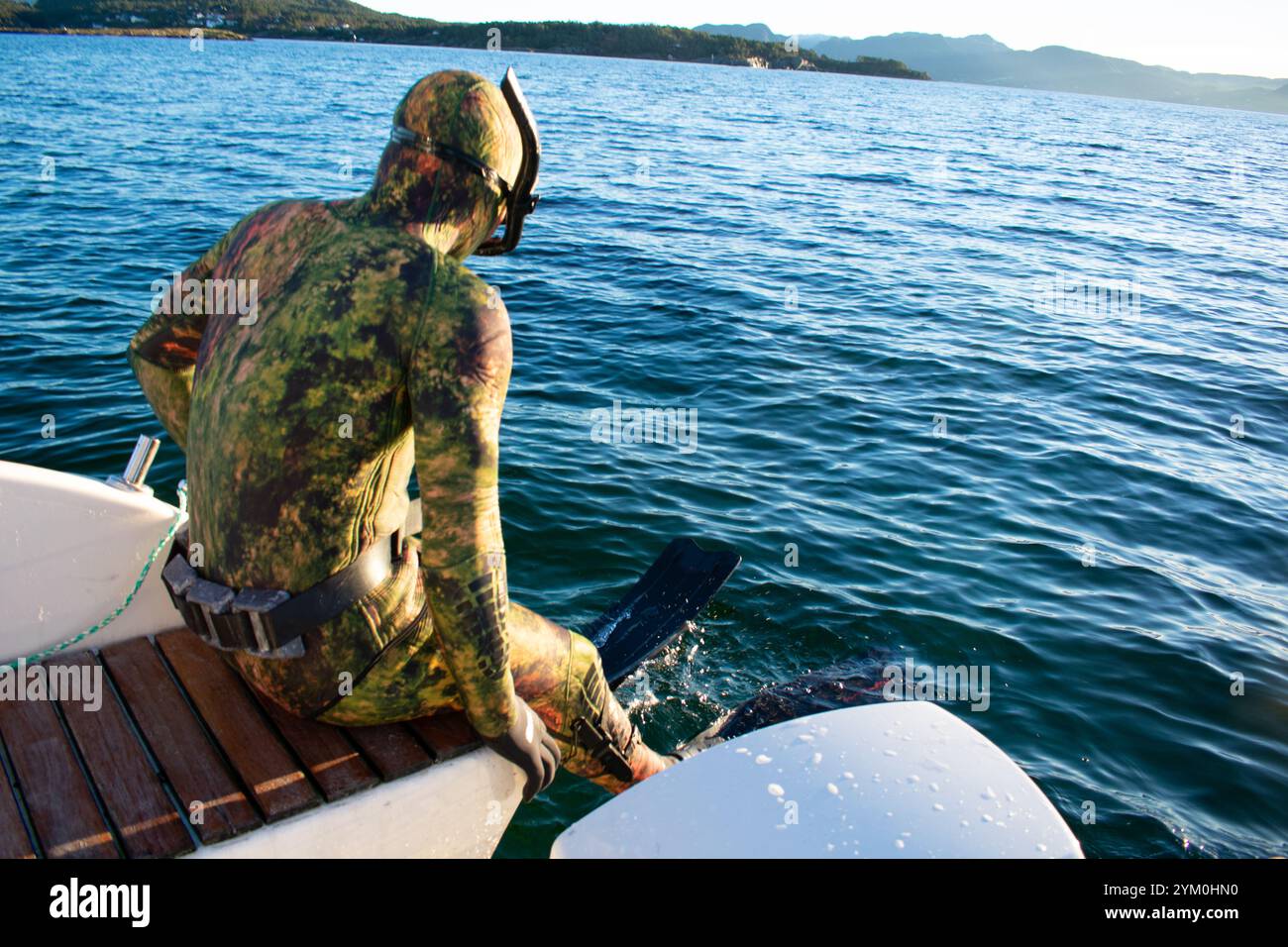 Diver in Scuba wetsuit jumping off a boat to Snorkel – Norway Vacations ...