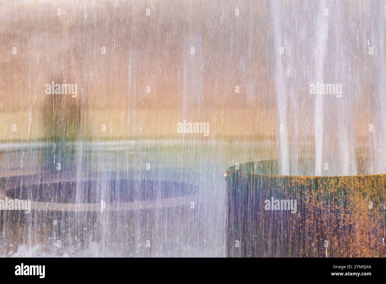 A vibrant rainbow forms over splashing water in a fountain Stock Photo ...