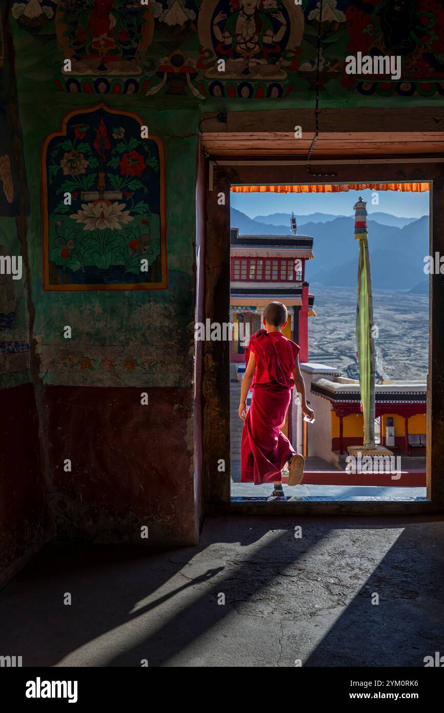 A young monk going through a door at Thiksey Monastery, Ladakh, India ...